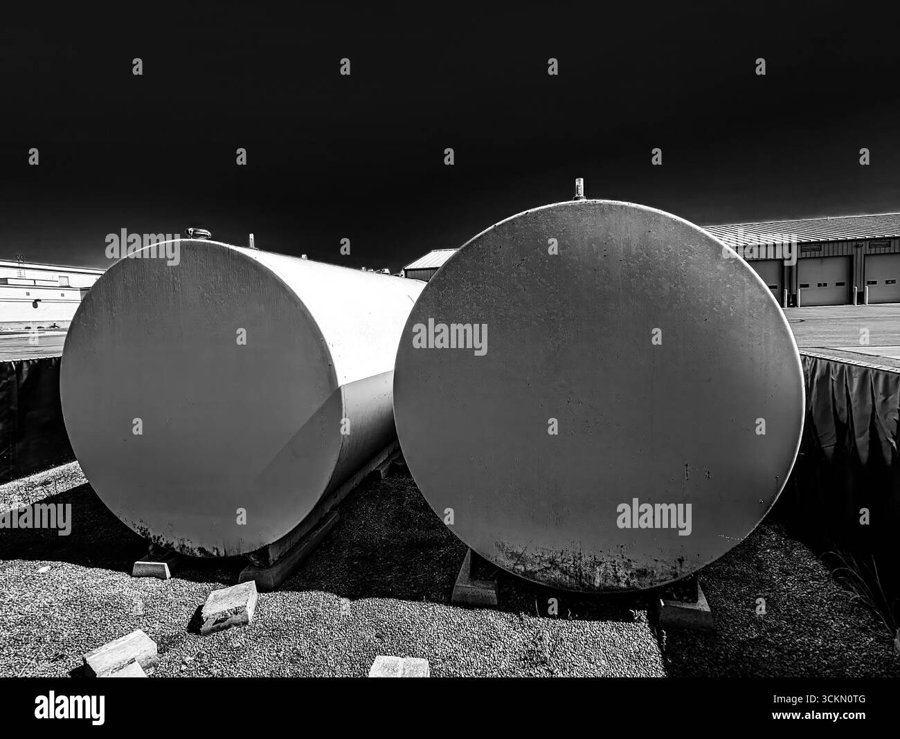 Large industrial storage tanks placed side by side in an outdoor ...
