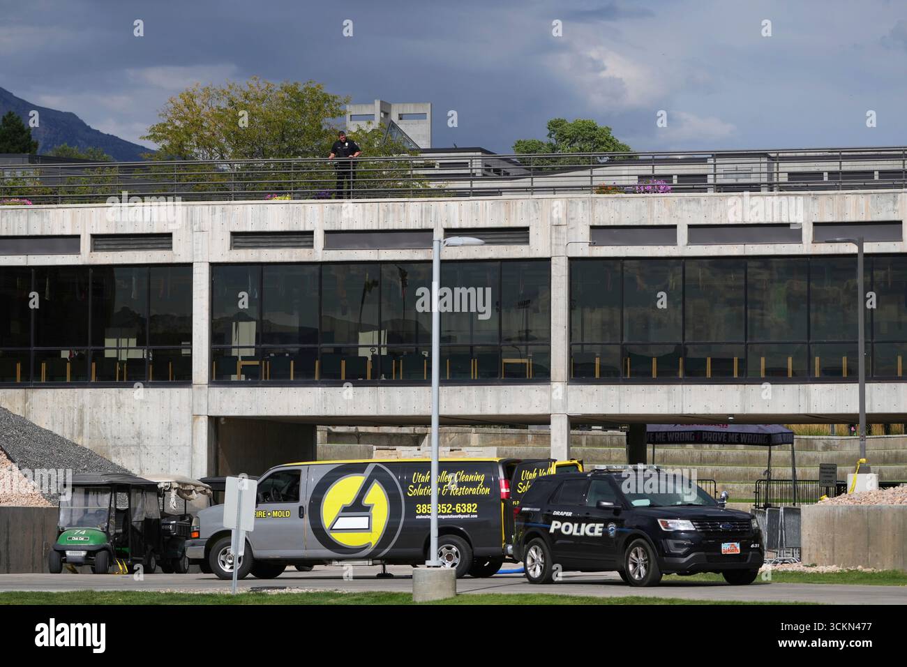 A police officer stands guard as people clean up the scene at Utah ...