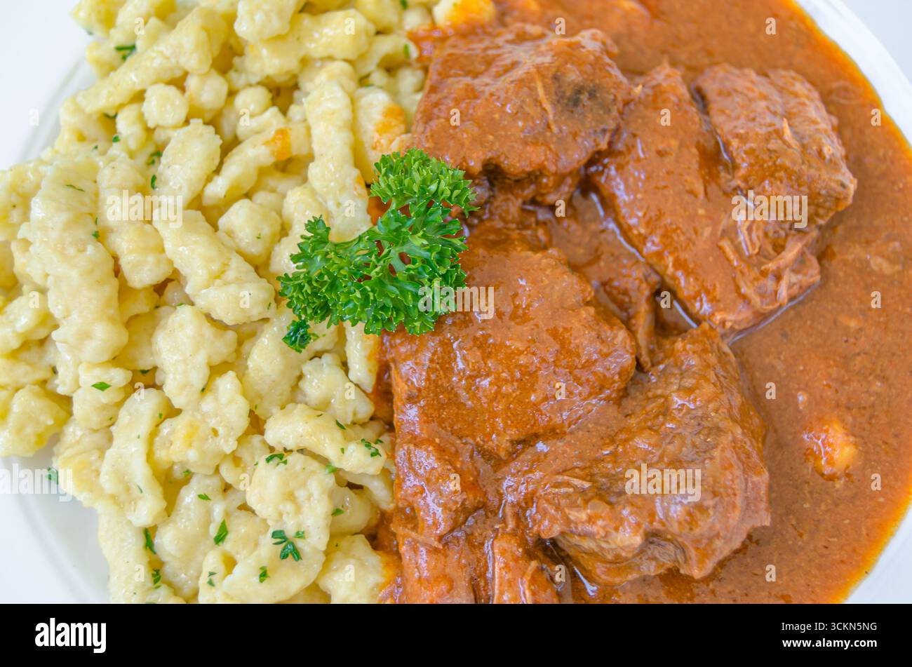 Spaetzle with meat stew, typical Austrian dish. Spaetzle are a type of ...
