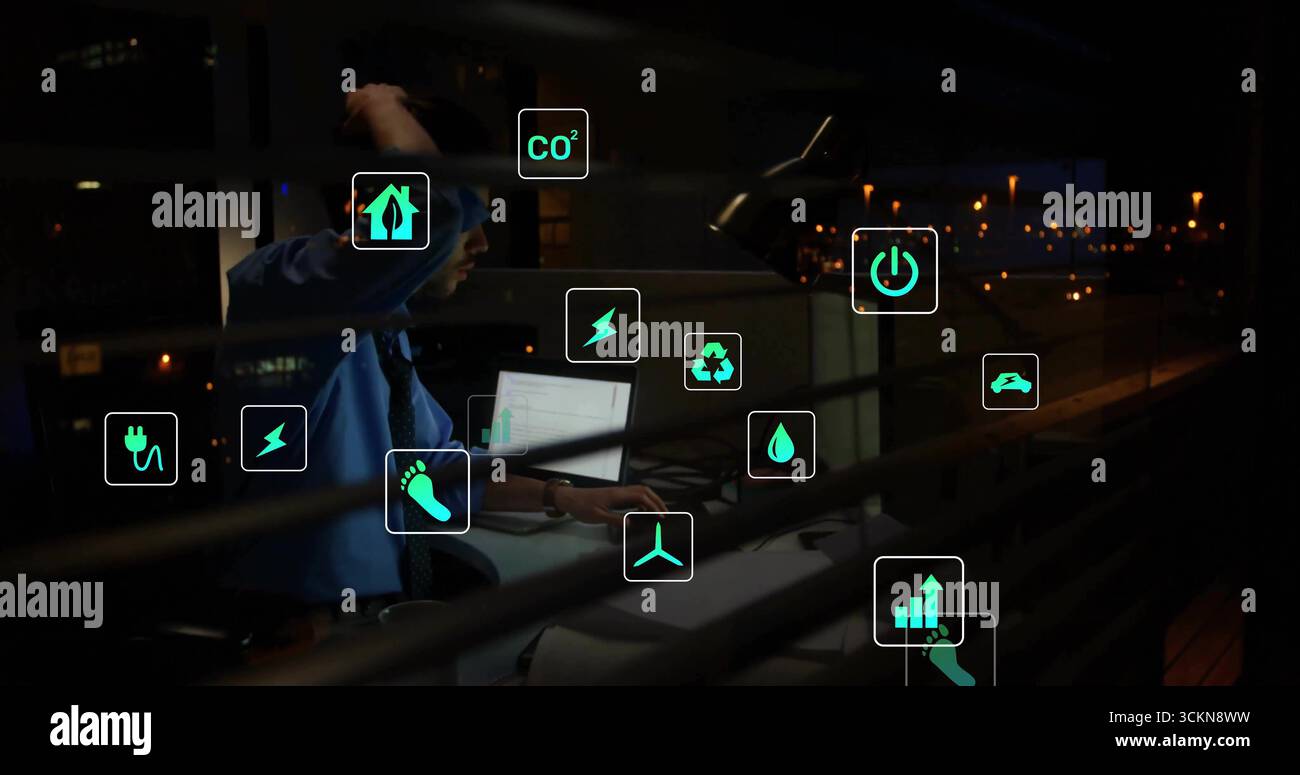 Reviewing engineer in tie monitoring laptop with eco icons at night ...
