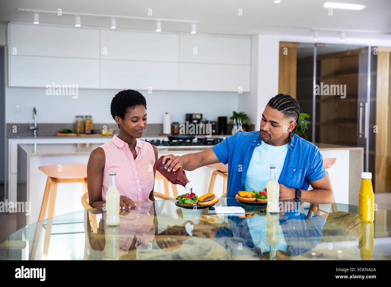 Diverse couple assembling burger hi-res stock photography and images ...