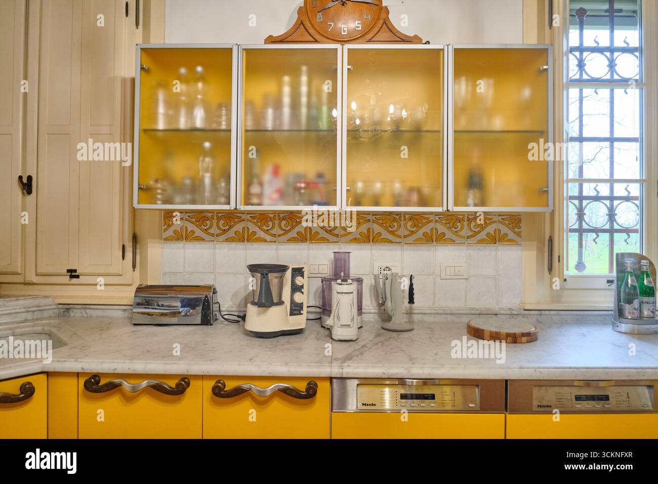 The big, yellow, country style kitchen. Dish, glass cabinet and ...