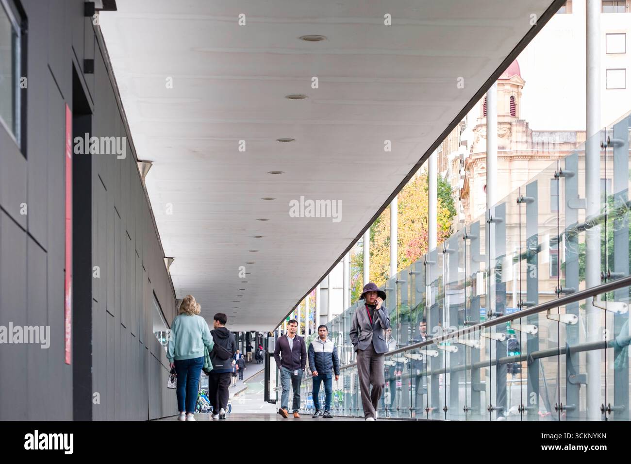 An outdoor urban walkway featuring people walking amidst modern ...