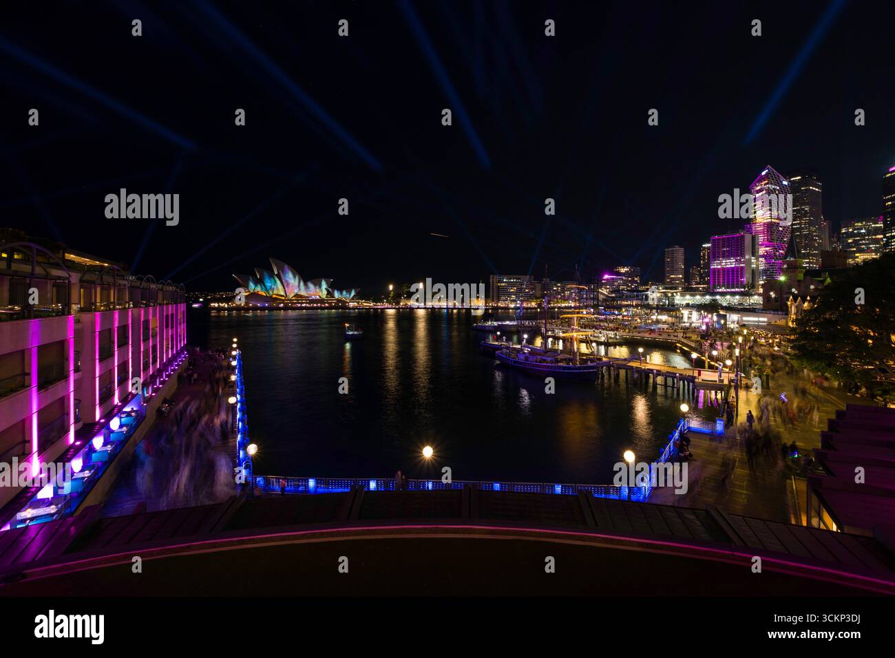 The Sydney Opera House is illuminated with vibrant colored lights ...