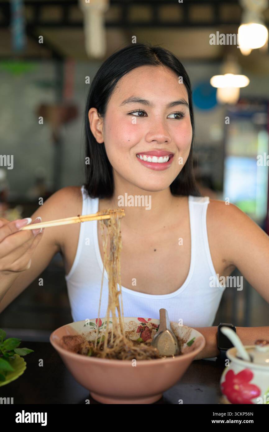 Beautiful young Thai woman eating famous Thailand street food boat ...