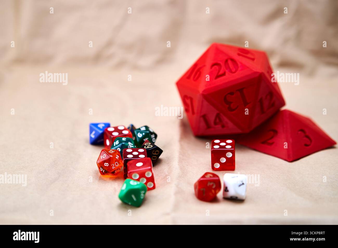 Several dice of different sizes and colors, with a red dice cup in the ...