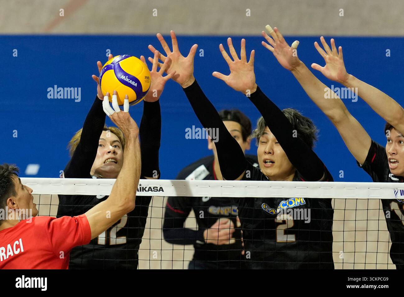 Ramazan Efe Mandiraci of Turkey tosses the ball against Japan players ...
