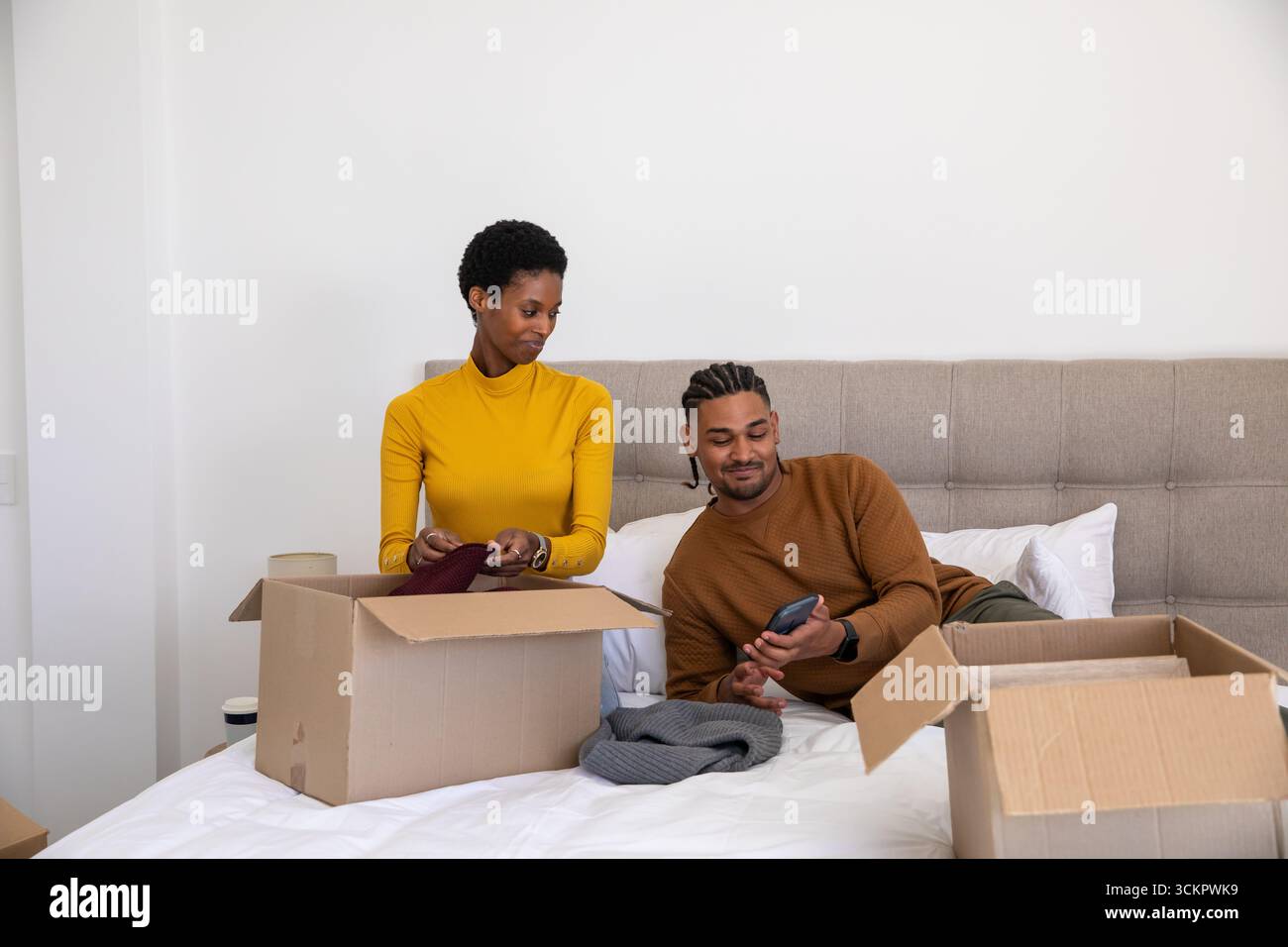 Diverse couple sorting clothing hi-res stock photography and images - Alamy