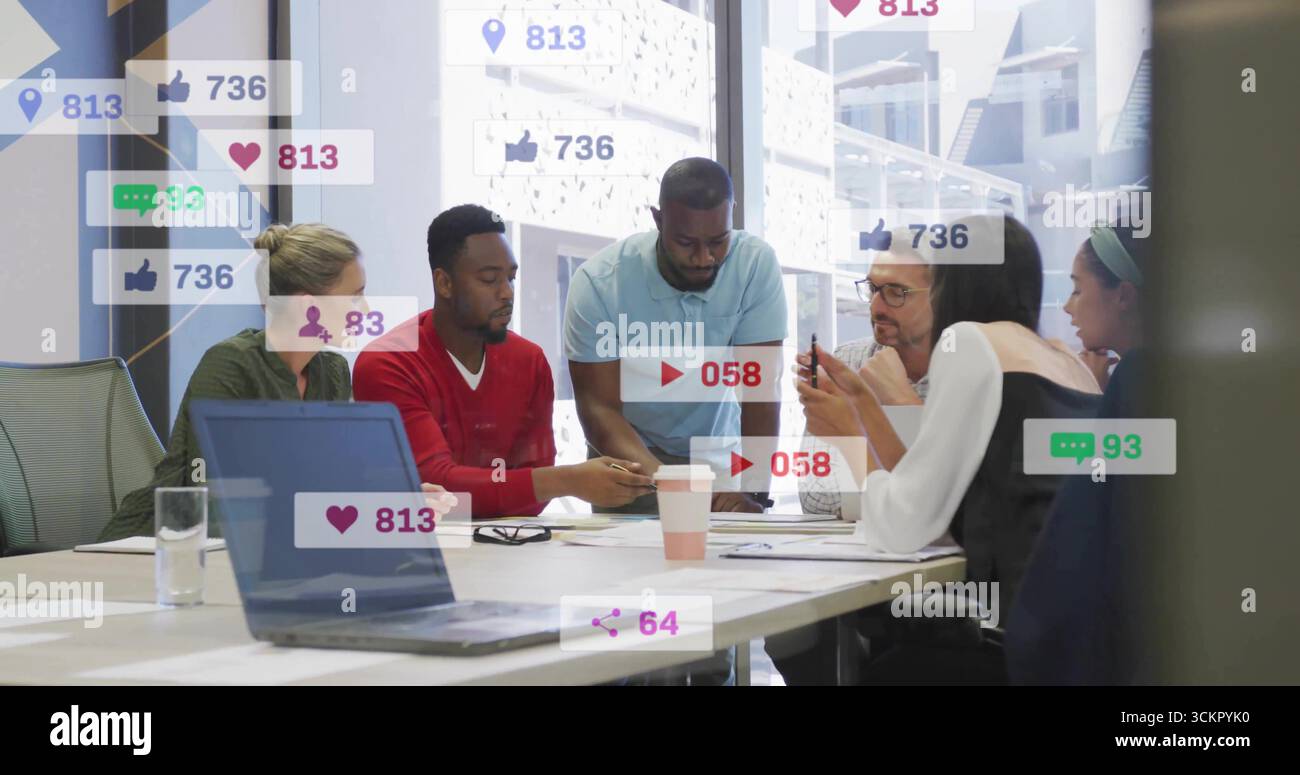 Collaborating team of six reviewing documents in boardroom, with ...