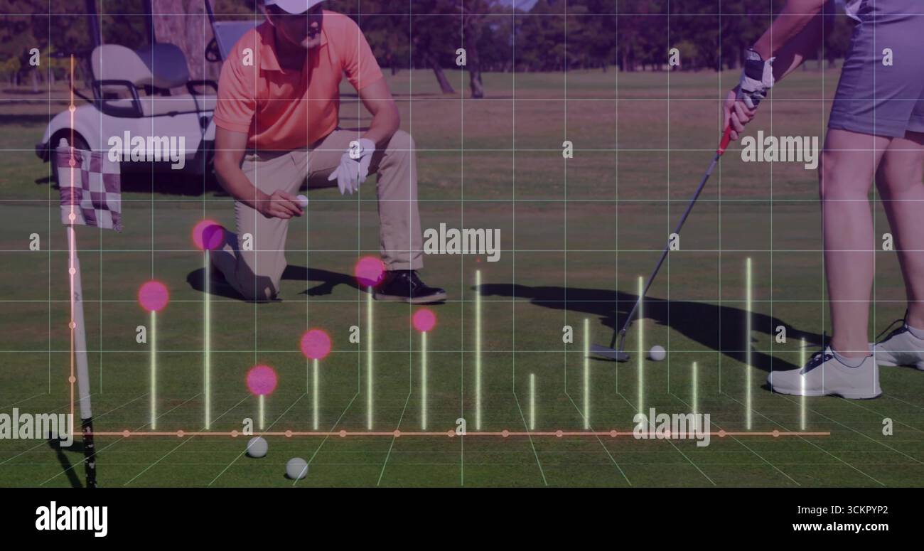 Standing woman lining up putt on sunlit green with crouching partner ...