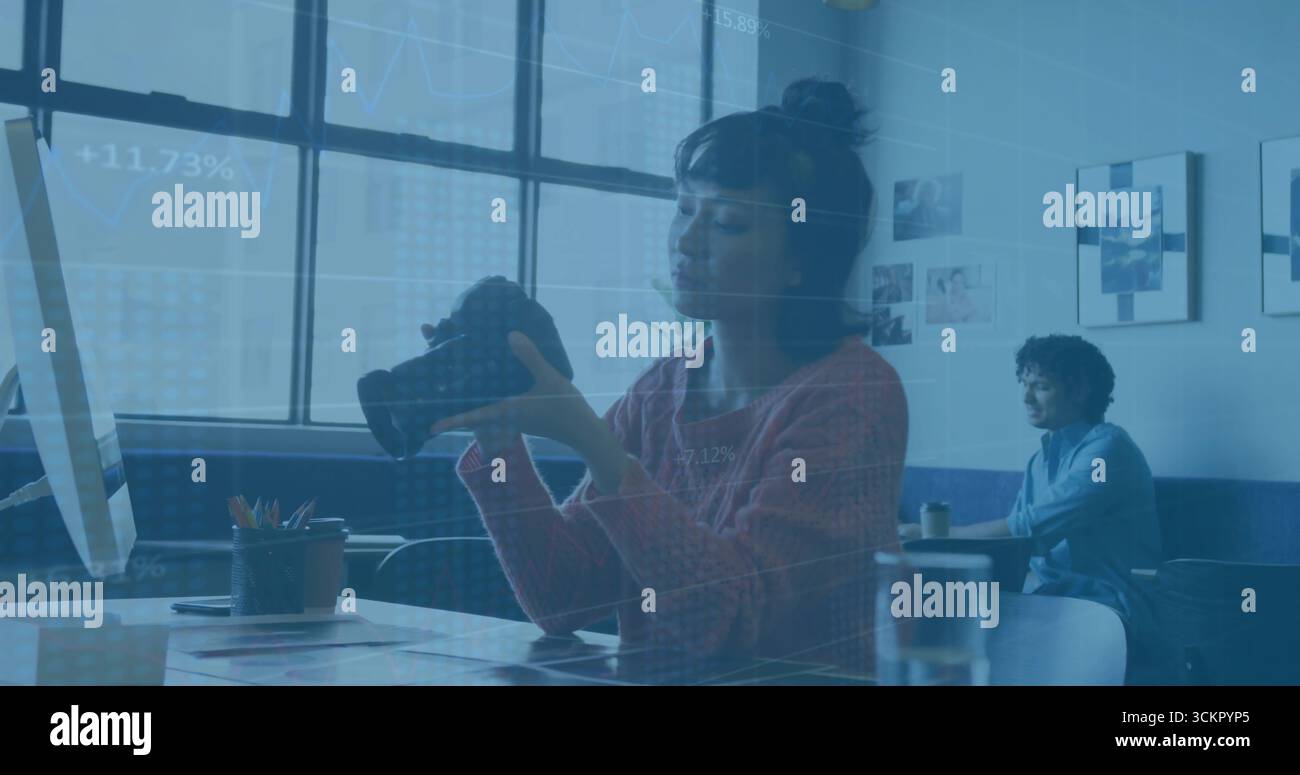Examining DSLR camera lens, Asian woman adjusting focus in office with ...