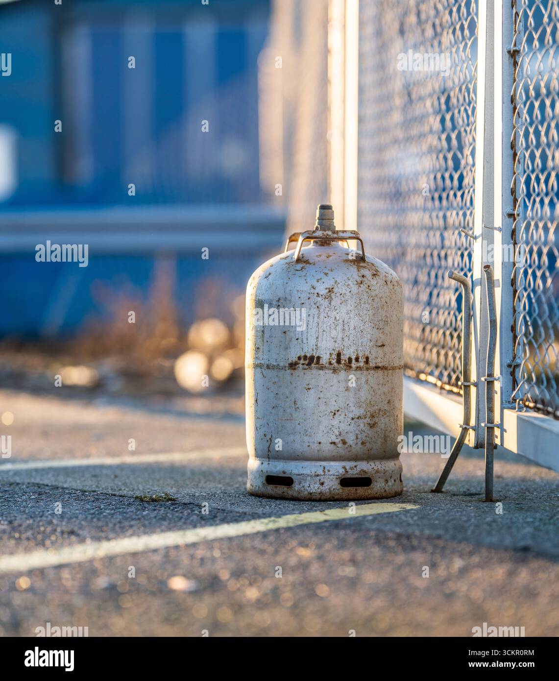 rusty propane cylinder beside chain-link fence Stock Photo - Alamy