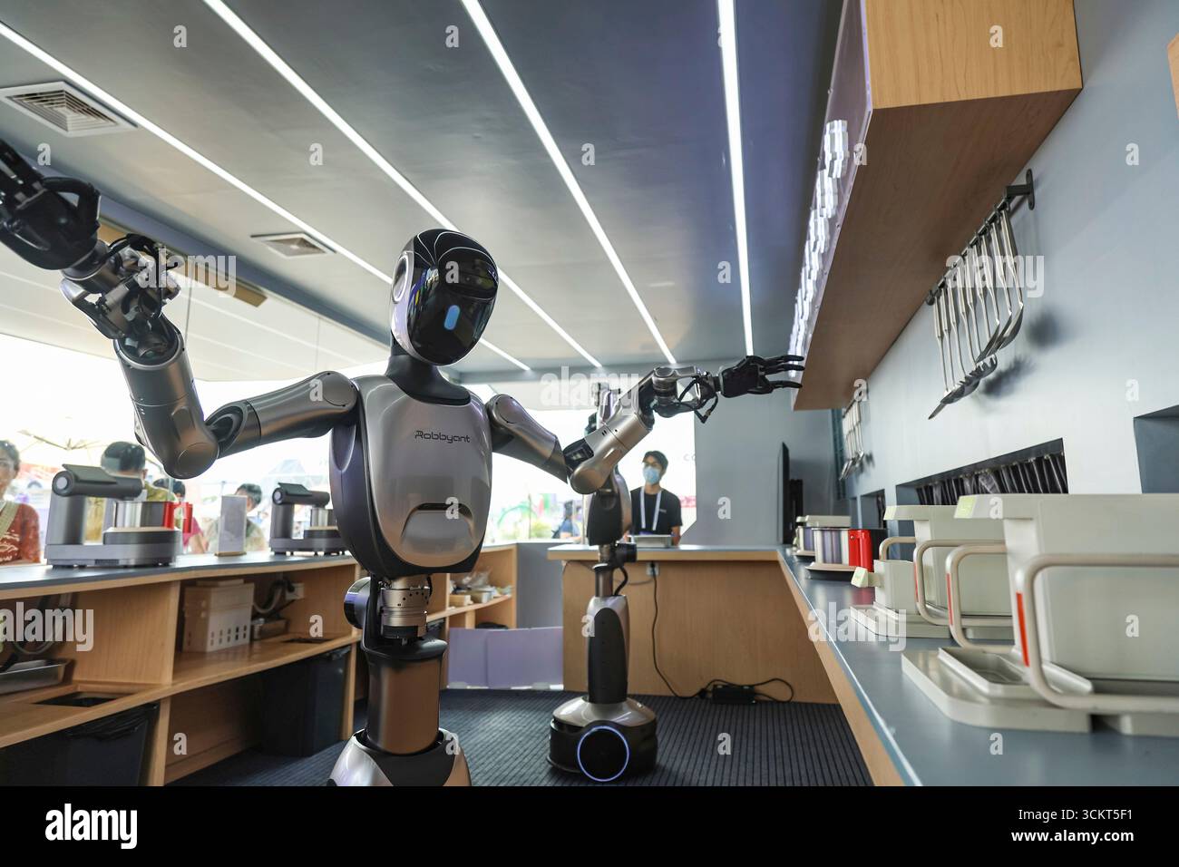 A robot cooks for customers at a canteen for the Inclusion Conference ...