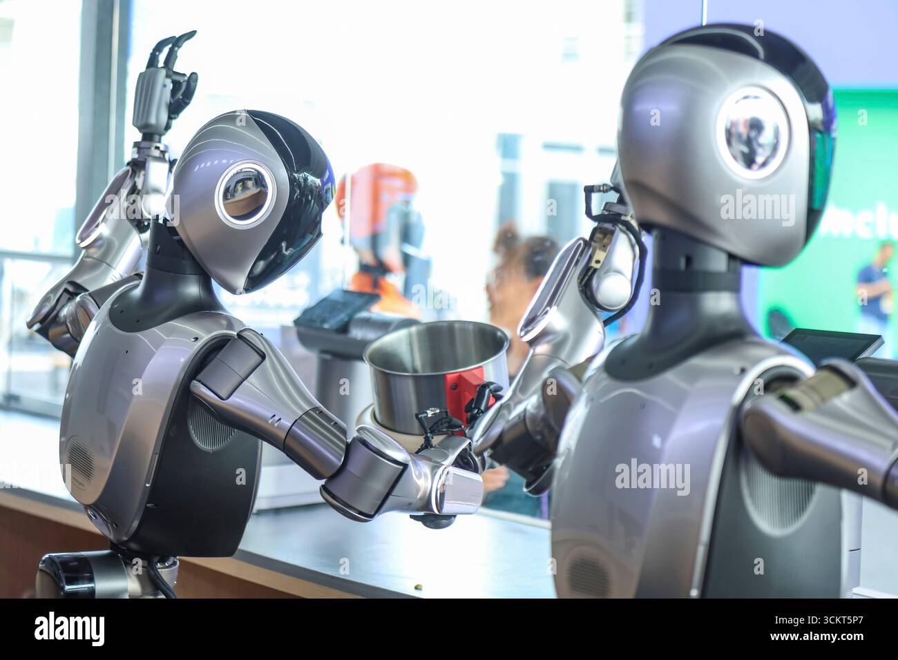 Two robots cook for customers at a canteen for the Inclusion Conference ...