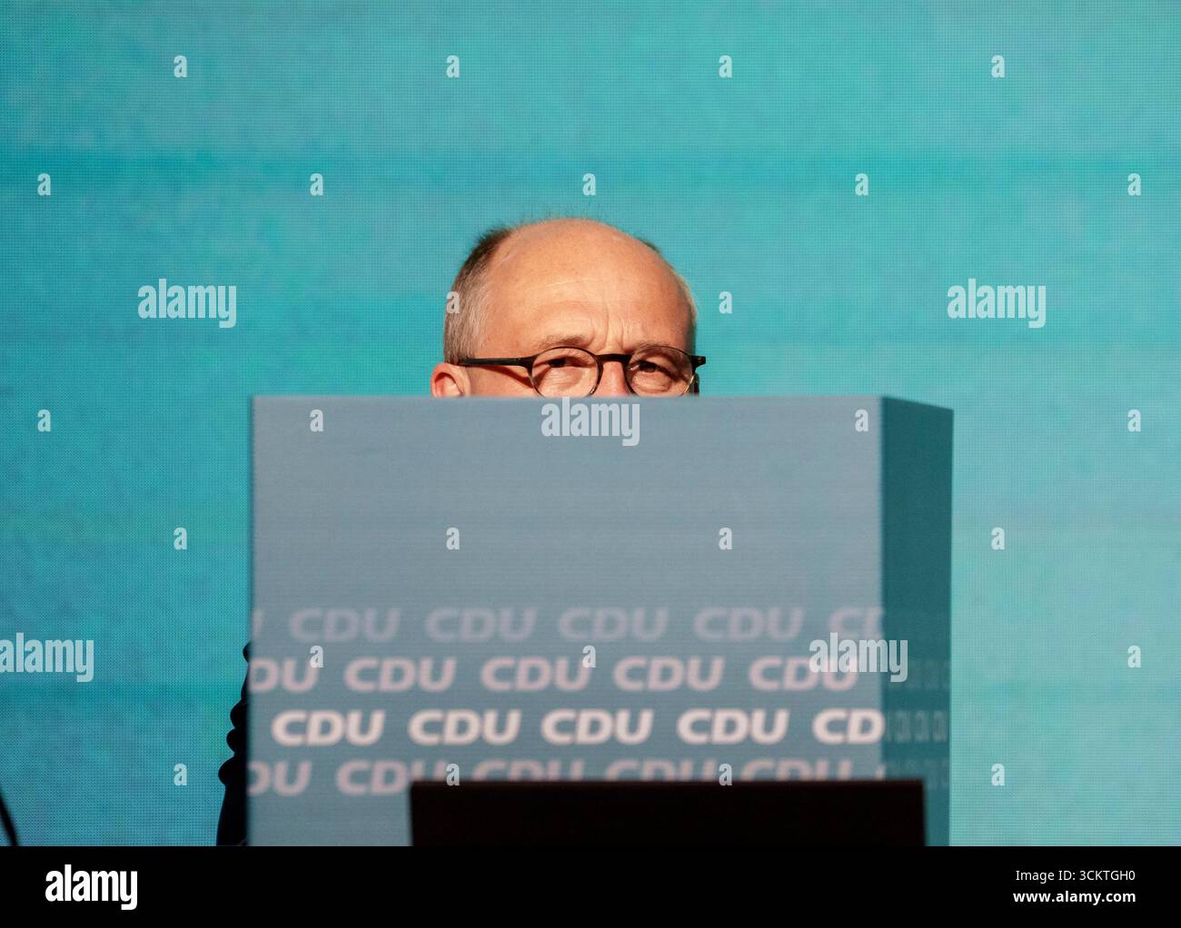 13 September 2025, Hesse, Darmstadt: A CDU party member holds his ...