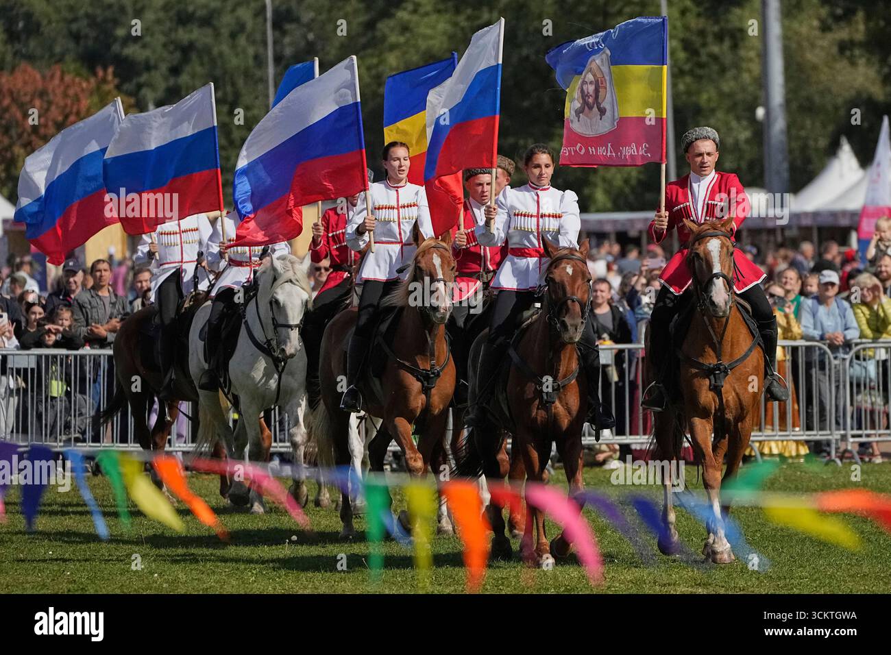 Cossacks with Russian and cossack's flags ride horse at the Cossack Village festival at Moscow's ...