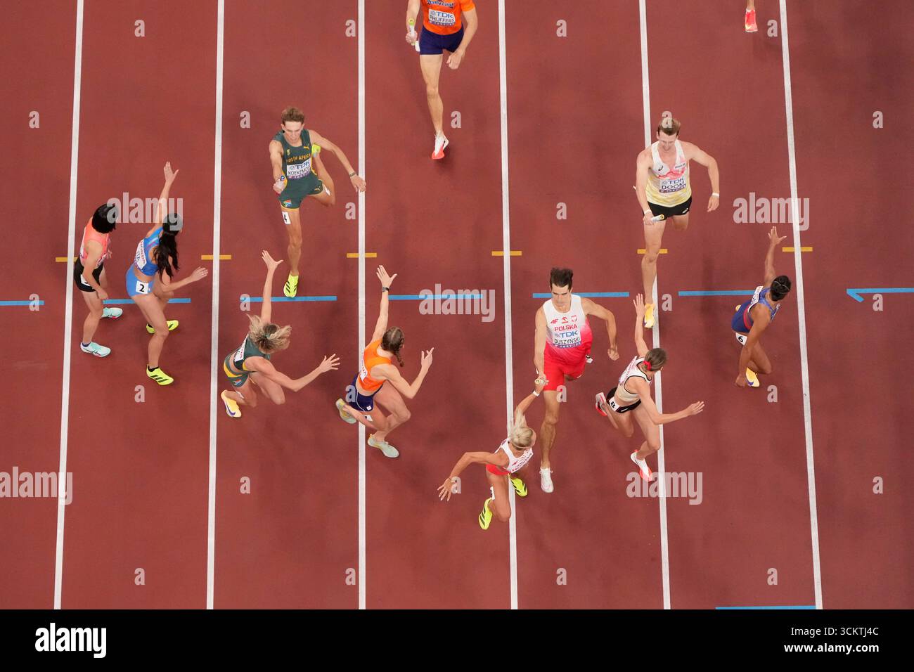Athletes pass the baton during the mixed 4 X 400 meters relay final at ...