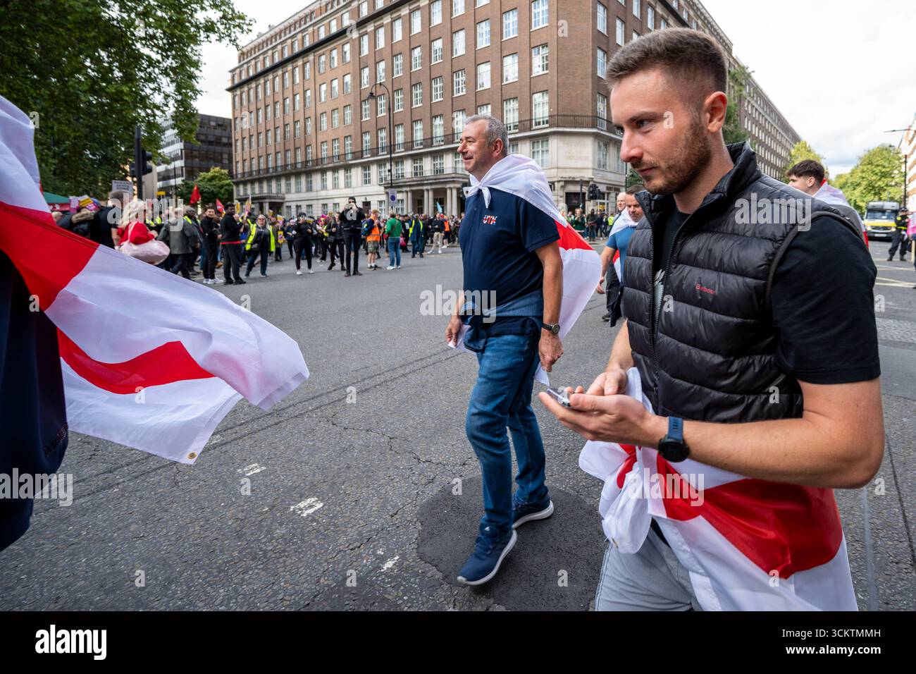 London, UK. 13 September 2025. Men wearing England flags pass by as ...