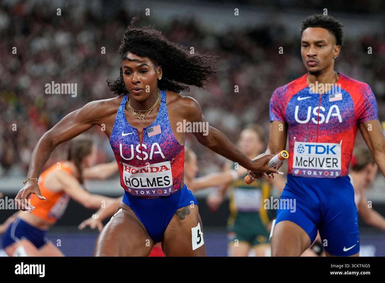 United States' Jenoah McKiver, right, hands off to Alexis Holmes, left ...
