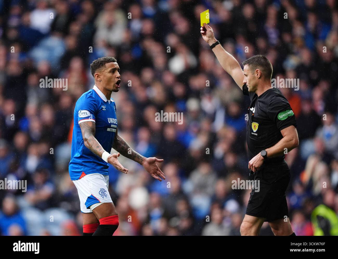 Rangers' James Tavernier (left) is booked by referee Steven McLean ...