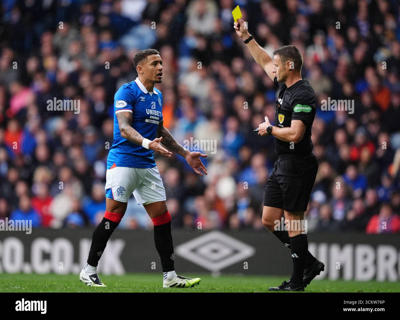 Rangers' James Tavernier (left) is booked by referee Steven McLean ...