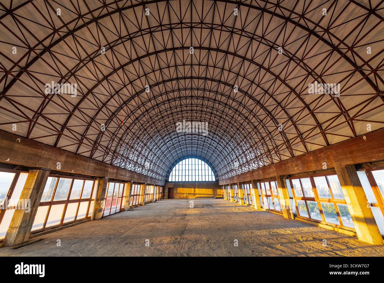 Interior view of an unfinished industrial building with a large arched ...