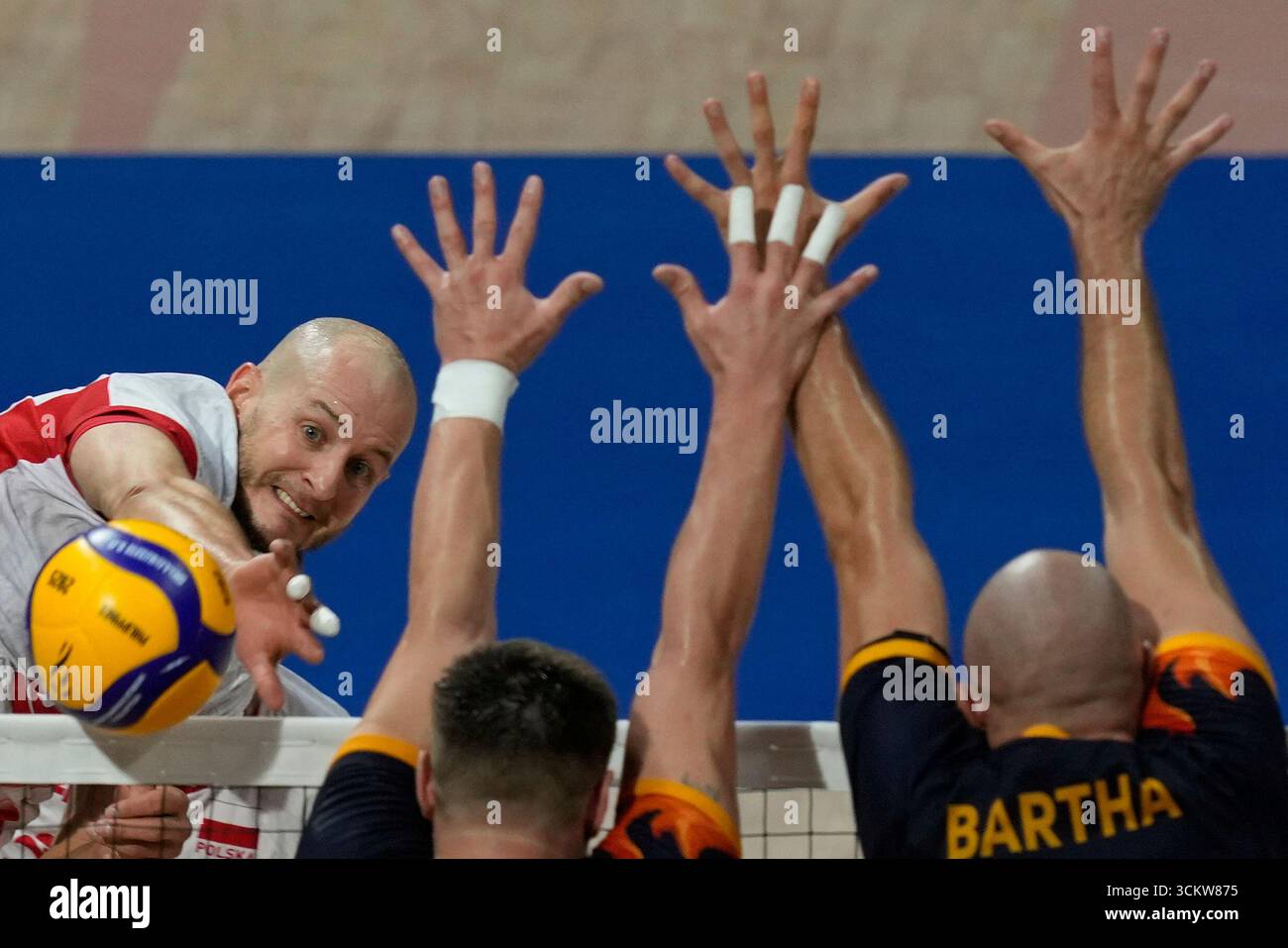 Bartosz Kurek, left, of Poland, spikes the ball against Robert Adrian ...