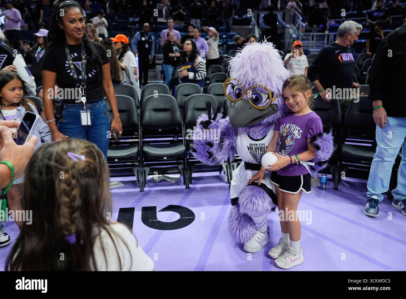 Violet, the Golden State Valkyries mascot, has a photo taken with a fan ...