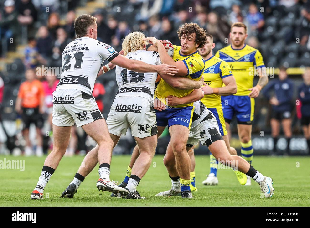 Max Wood of Warrington Wolves is tackled by Brad Fash of Hull FC during ...
