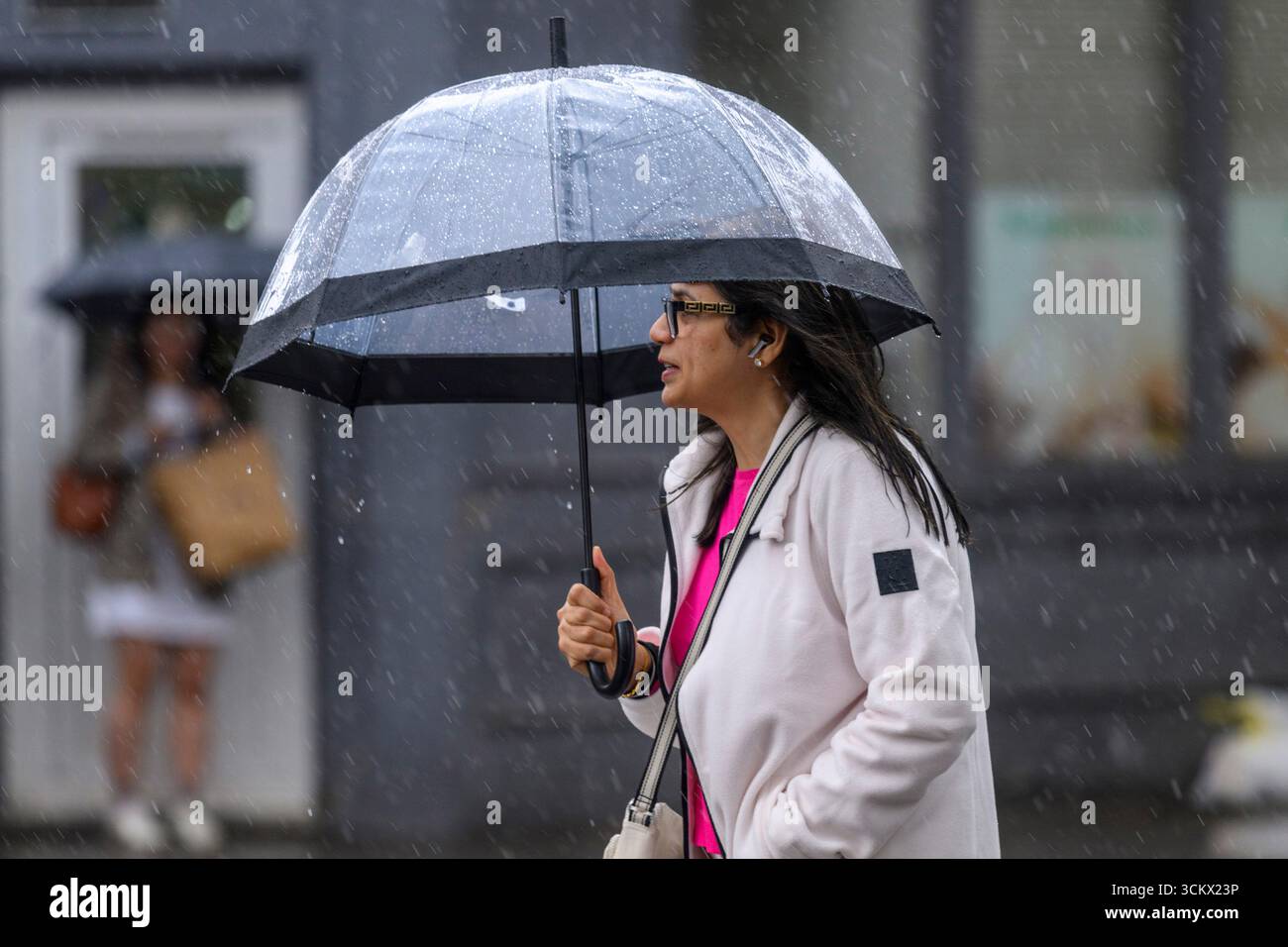 13/09/2025. London, UK People walk along the road during heavy rain ...