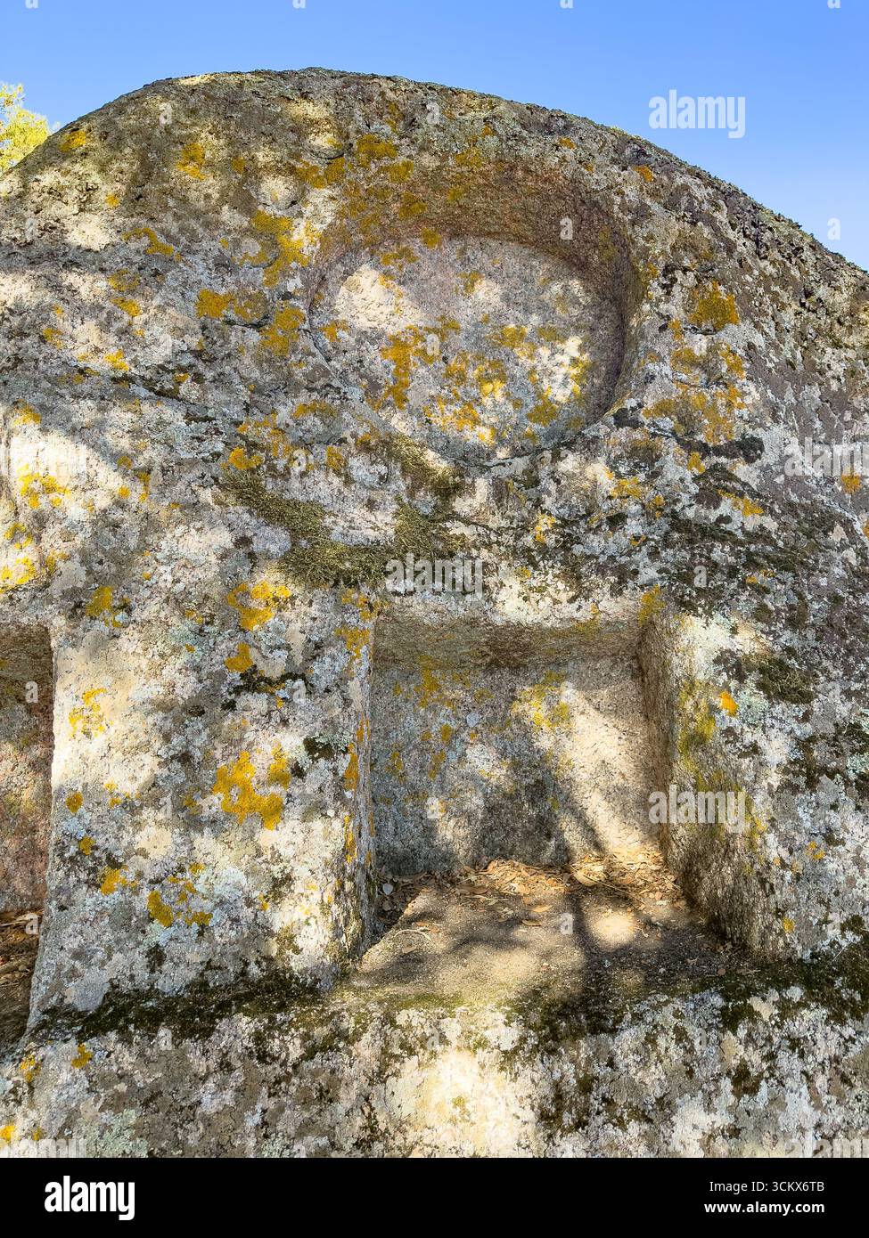 Ancient rock-cut altar with multiple niches under oak trees in Sardinia ...