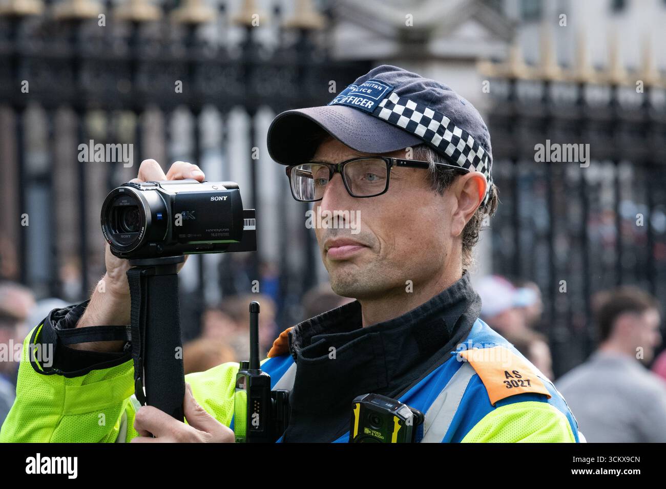 London, UK. 13 September, 2025. A police officer films the crowd as ...
