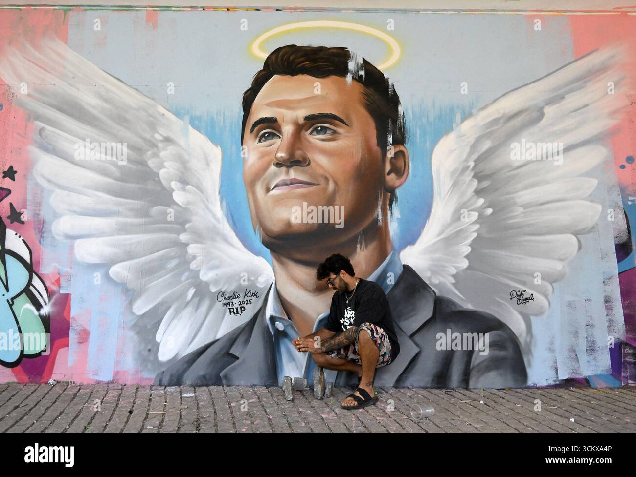 Dudi Shoval, Israeli graffiti artist, lights a memorial candle in front ...