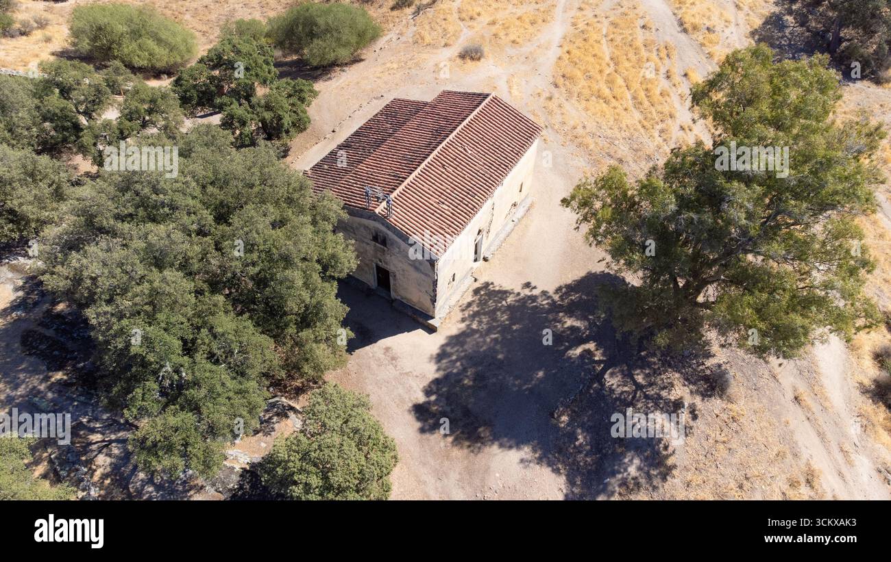 Small countryside stone church surrounded by trees and dry hills in ...