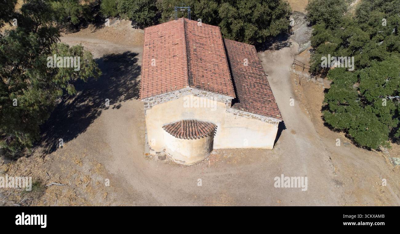 Small countryside stone church surrounded by trees and dry hills in ...