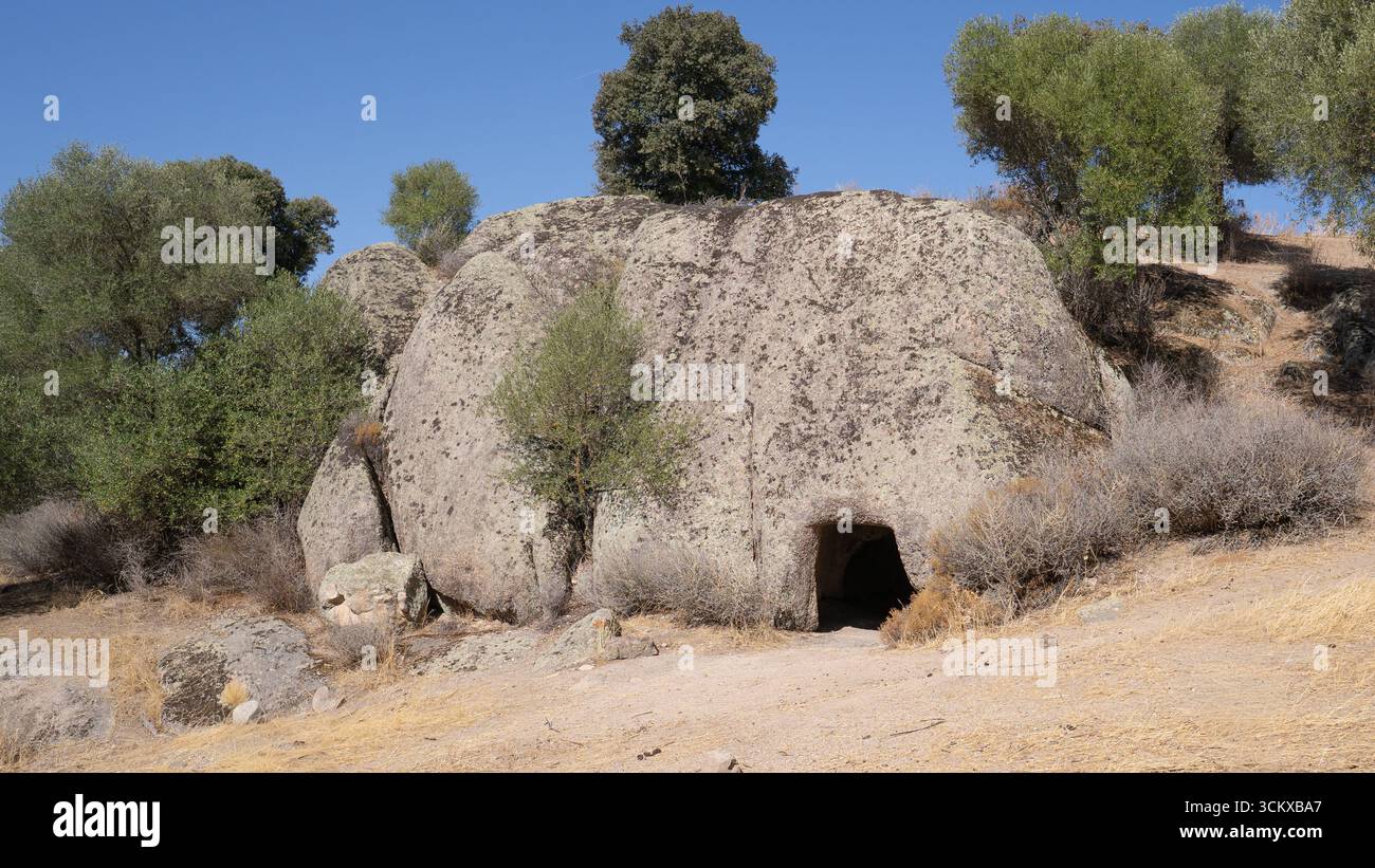Prehistoric chamber tomb carved into rock with natural arch-shaped ...