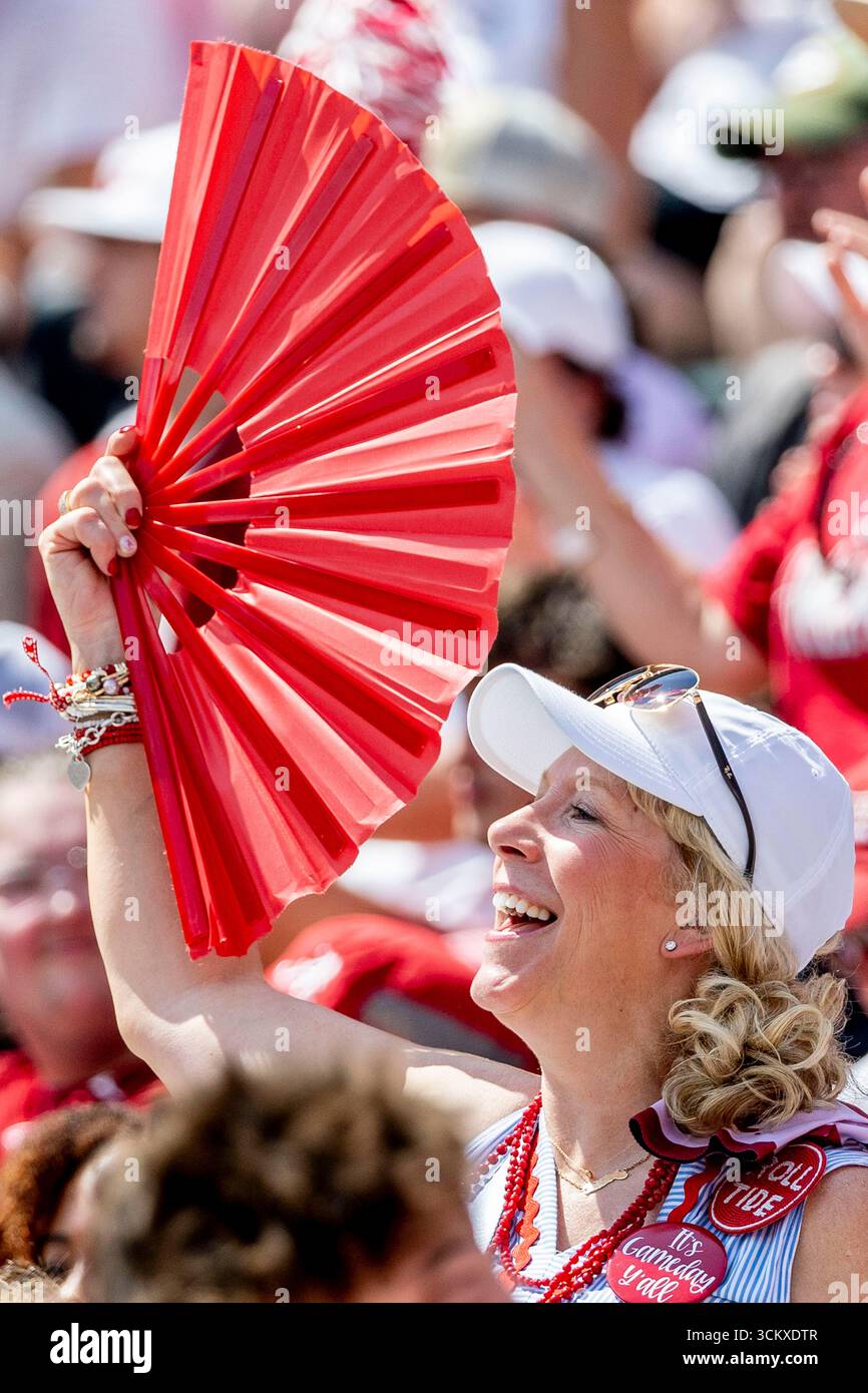 An Alabama fan fights the heat with an oversized paper fan during the ...