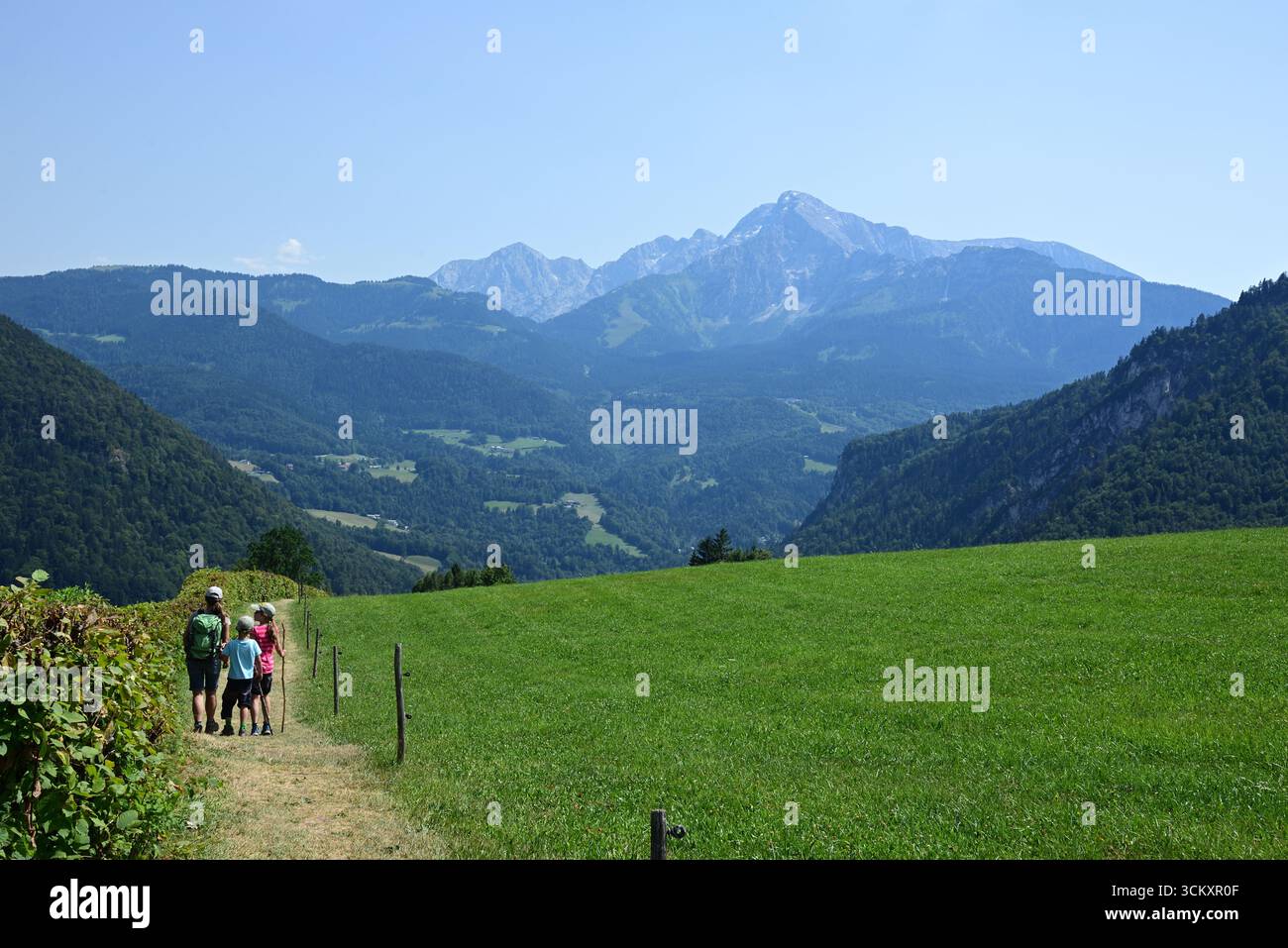 A family with a child takes a break on a hiking trail, enjoying the ...