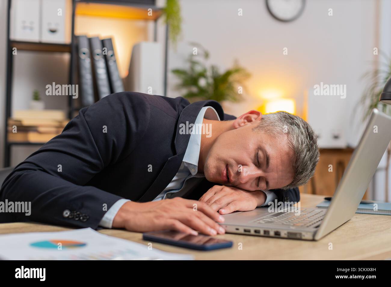 Bored sleepy businessman working on laptop computer leaning on hand ...