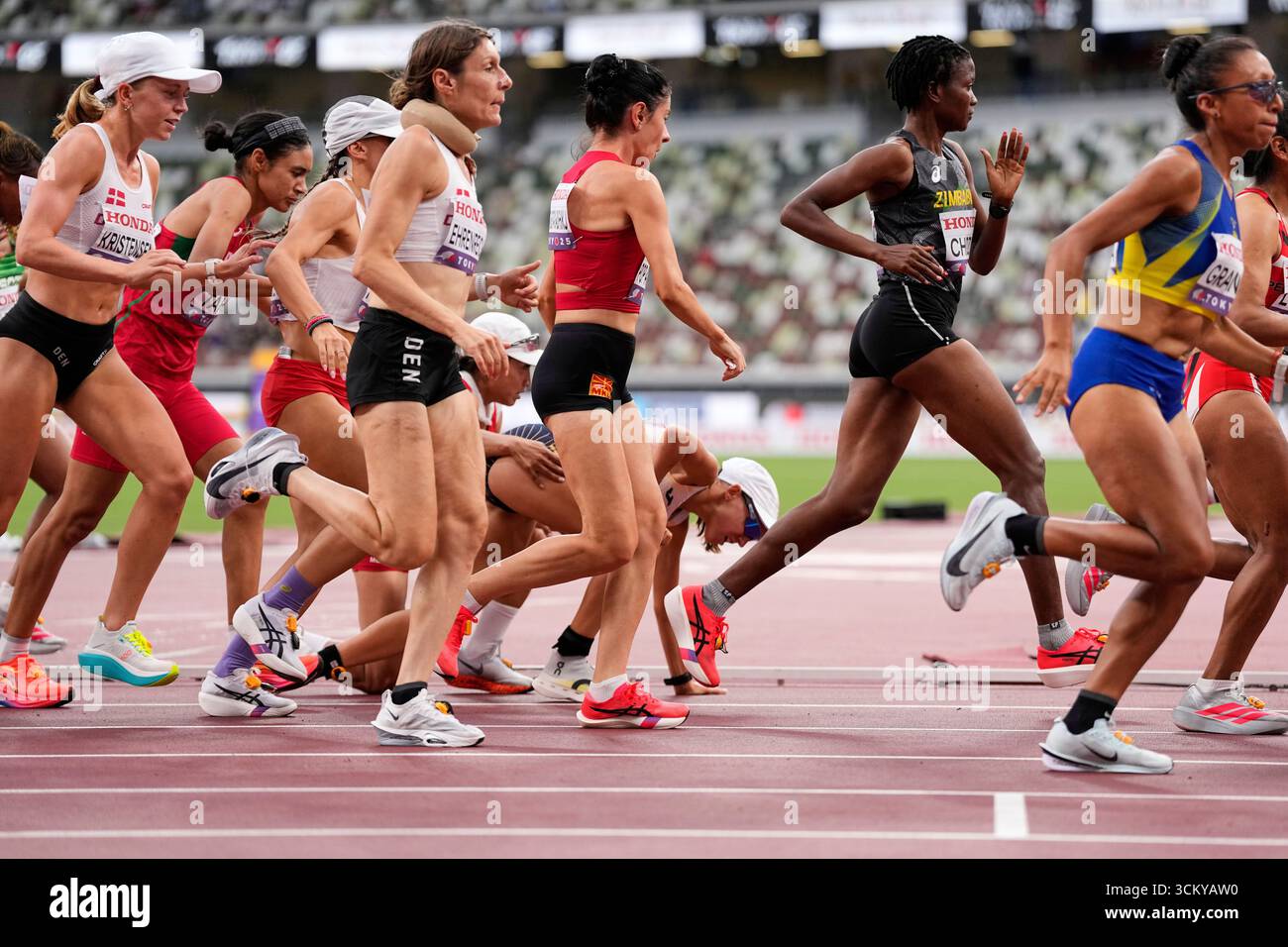 Runners get to their feet after falling in the women's marathon at the ...