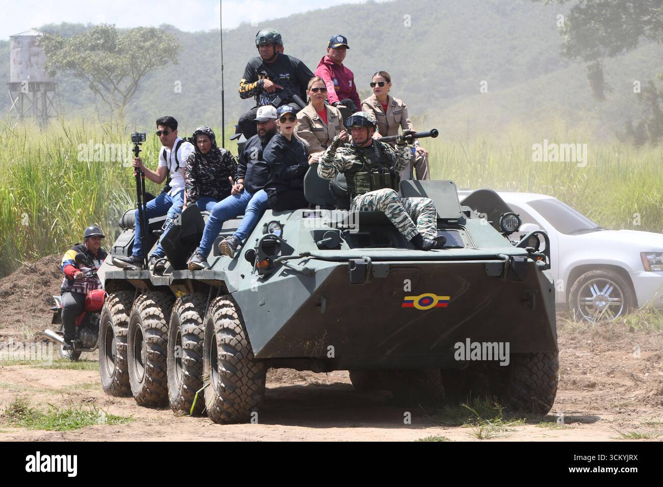 Members of the government-organized militias ride a tank during ...