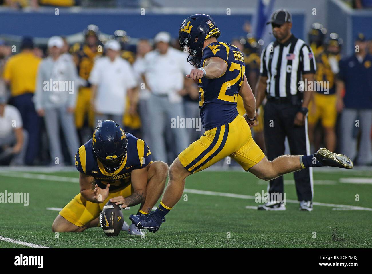 West Virginia place kicker Kade Hensley (25) kicks and punter Oliver ...