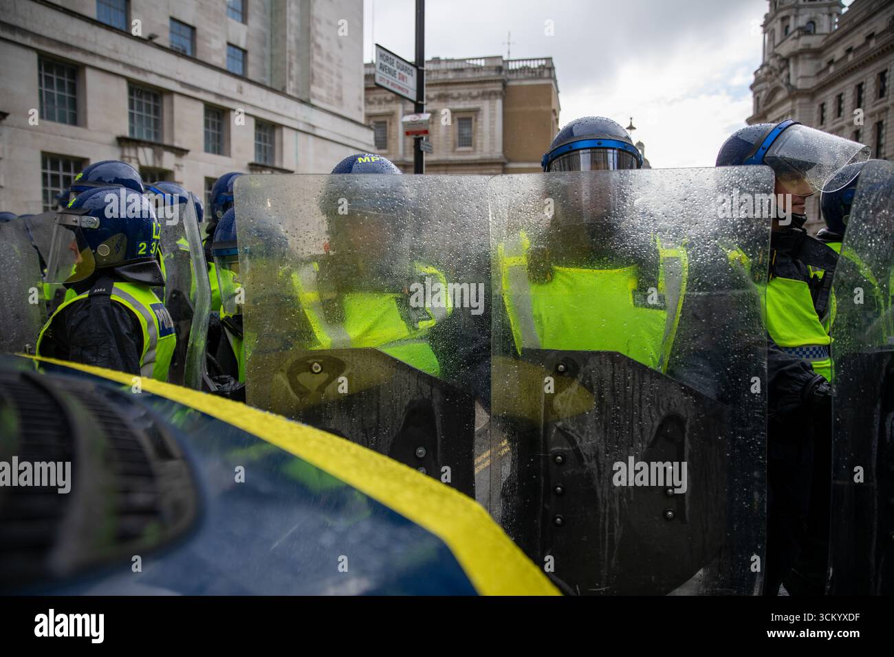 Metropolitan police officers seen wearing helmets and carrying rain ...