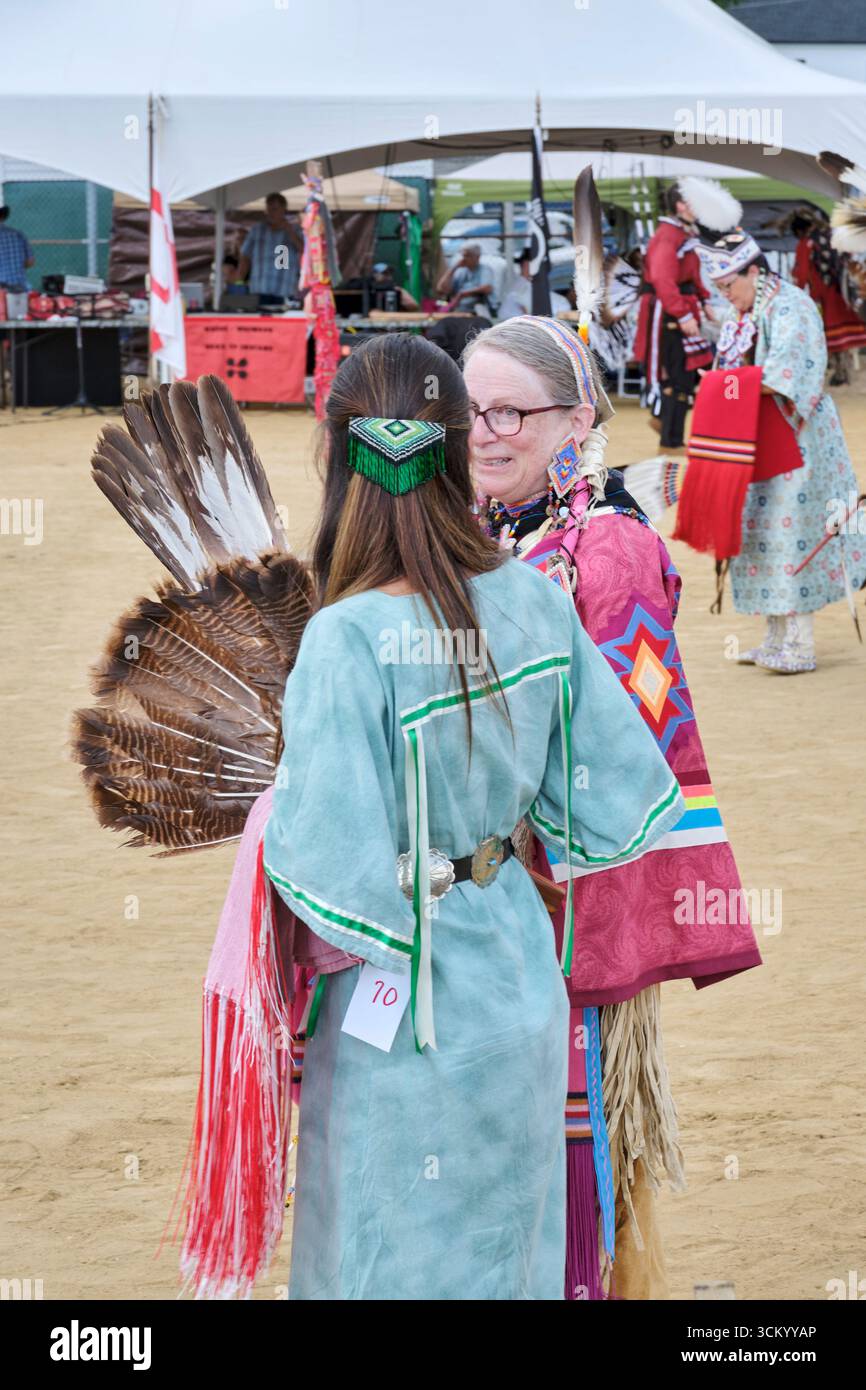 Participants in traditional regalia join an intertribal dance at the ...