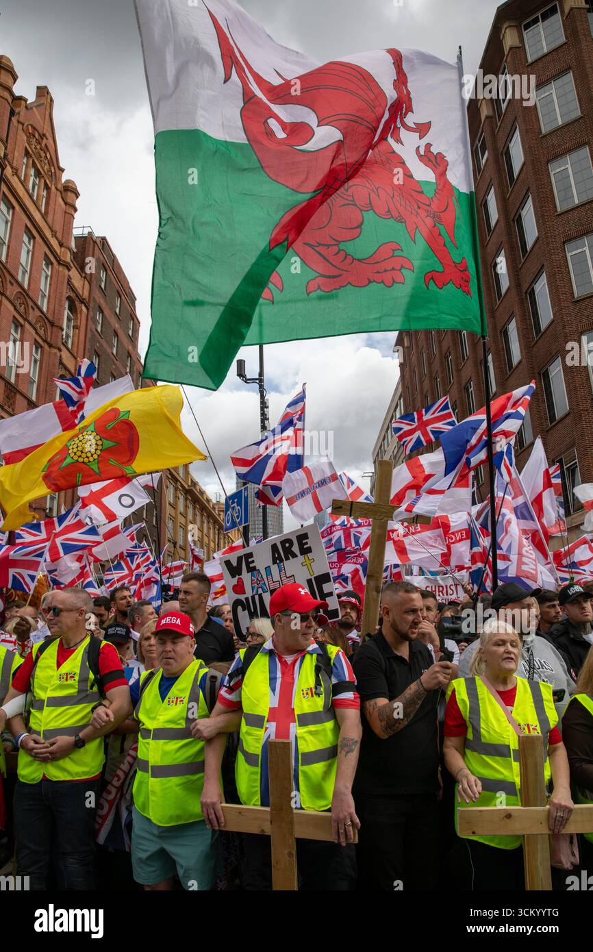 People stand beneath a Welsh national flag during a demonstration. The ...