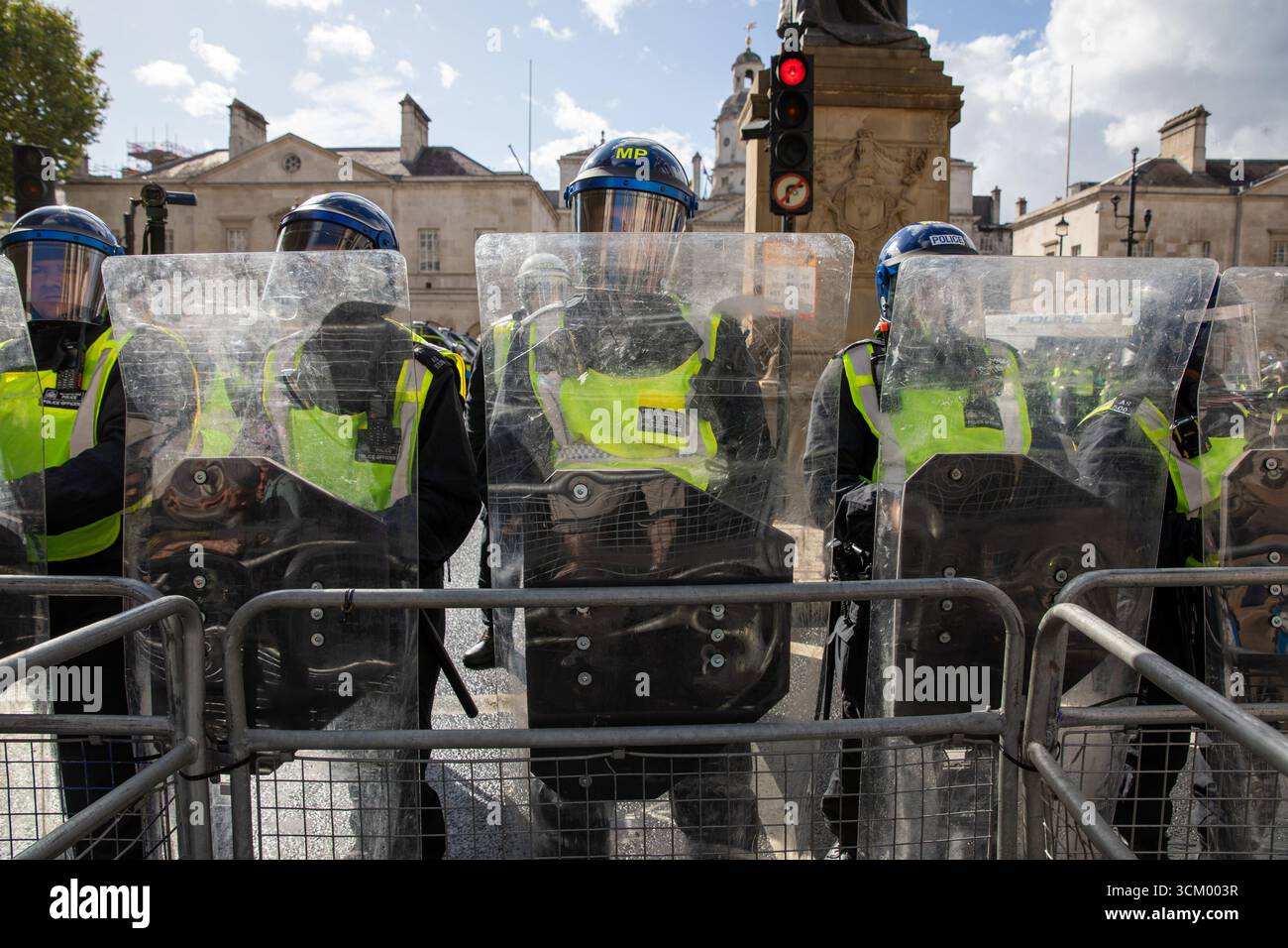Metropolitan Police riot officers stand behind barricades at a ...