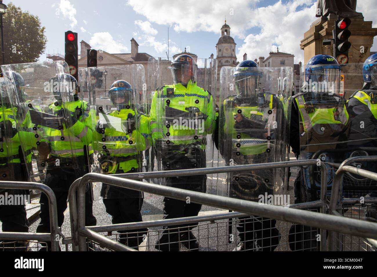 Metropolitan Police riot officers stand behind barricades at a ...