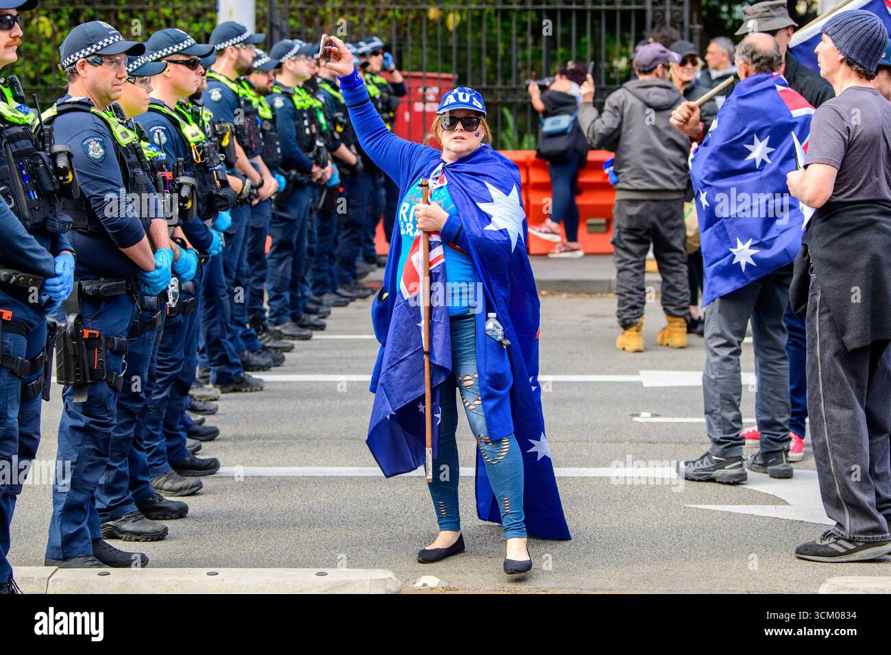 An anti-immigration protester wrapped in an Australian flag seen on ...