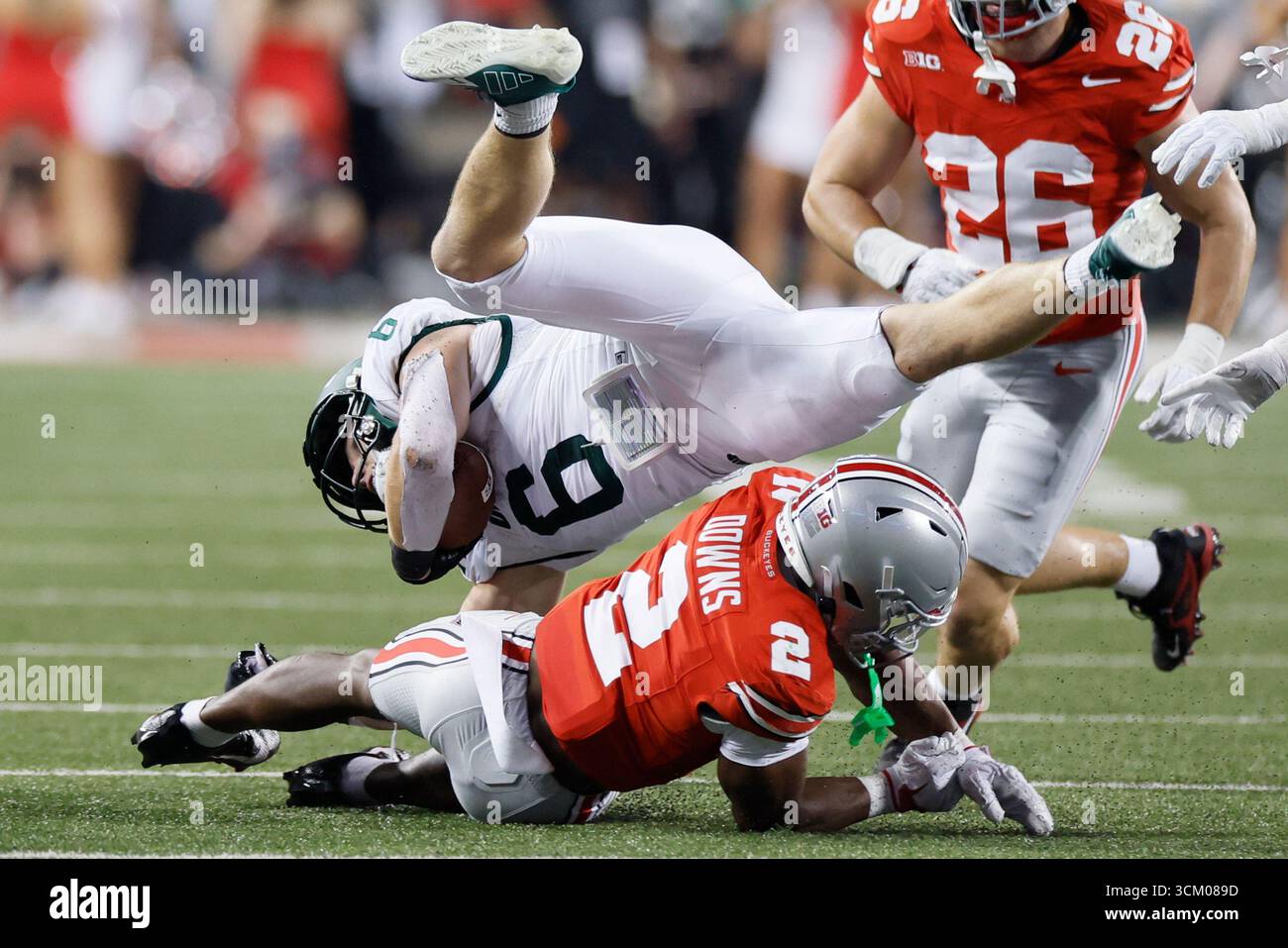 Ohio State defensive back Caleb Downs, bottom, tackles Ohio running ...