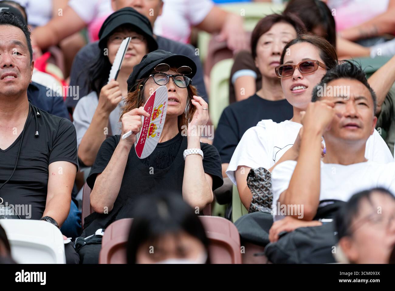 Tokyo, Japan 20250914. Japanese fans do everything they can to keep the sun and heat out during ...